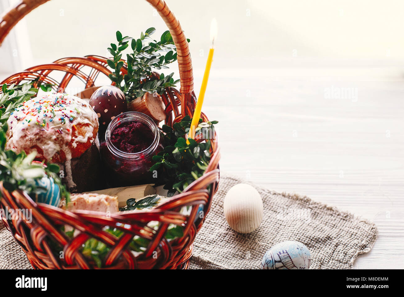 happy Easter concept. stylish basket with painted eggs, bread, ham ...