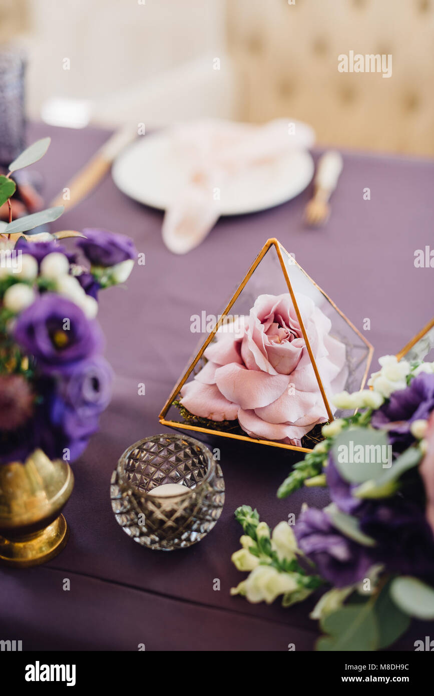 Pink and violet flowers in florariums decorate dinner table for ...