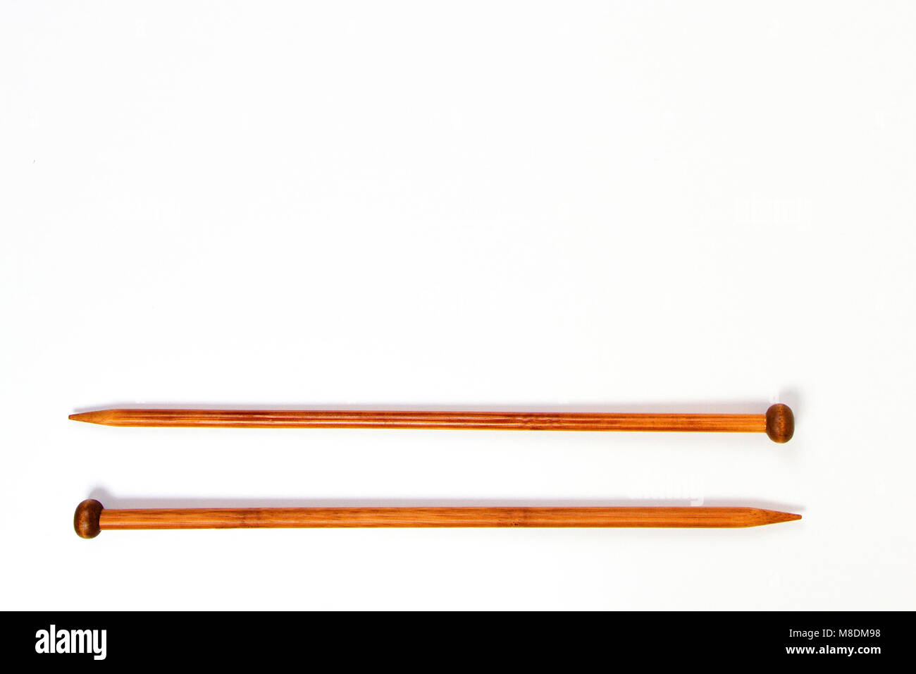 A pair of wooden knitting needles on white background Stock Photo - Alamy