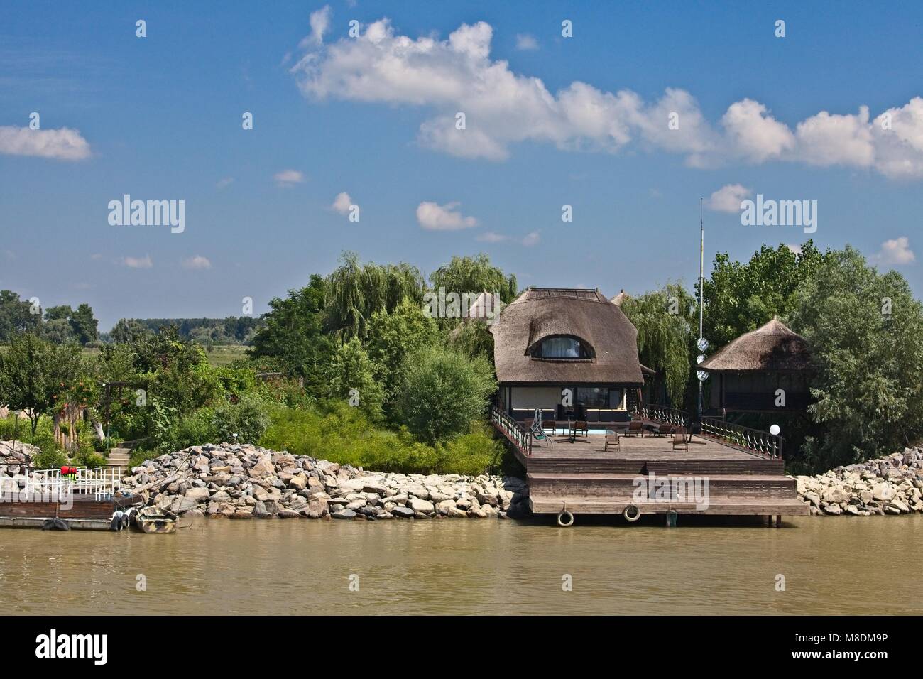 MODERN THATCHED HOUSE AND RIVER BANK FLOOD PROTECTION DOWNSTREAM OF ...
