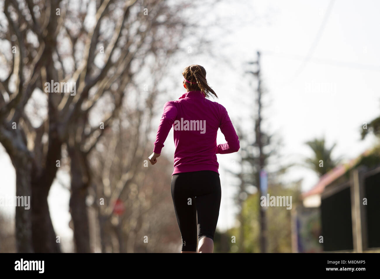 Rear view of young woman jogging Stock Photo - Alamy