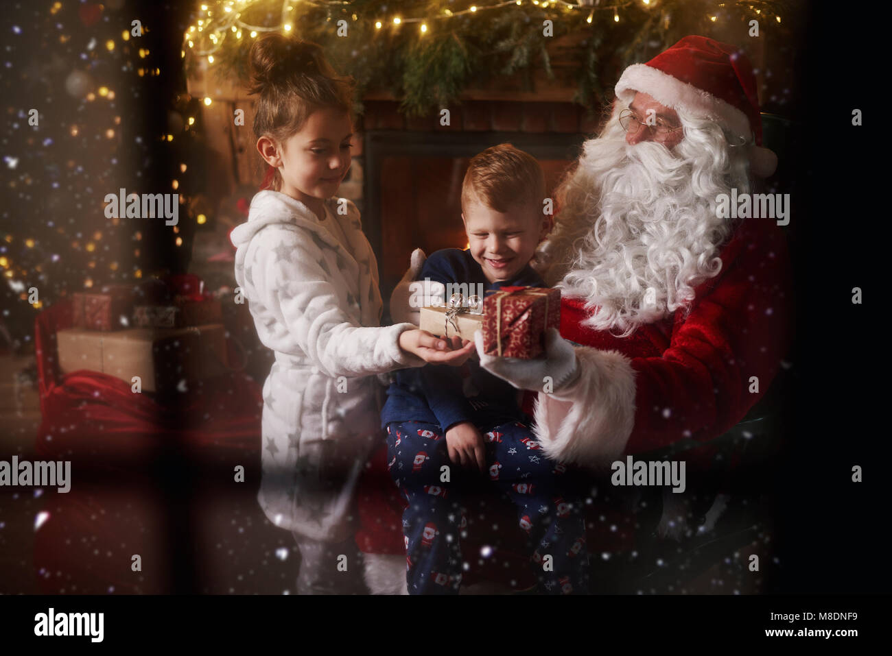 Young girl and boy receiving gifts from Santa Claus Stock Photo - Alamy