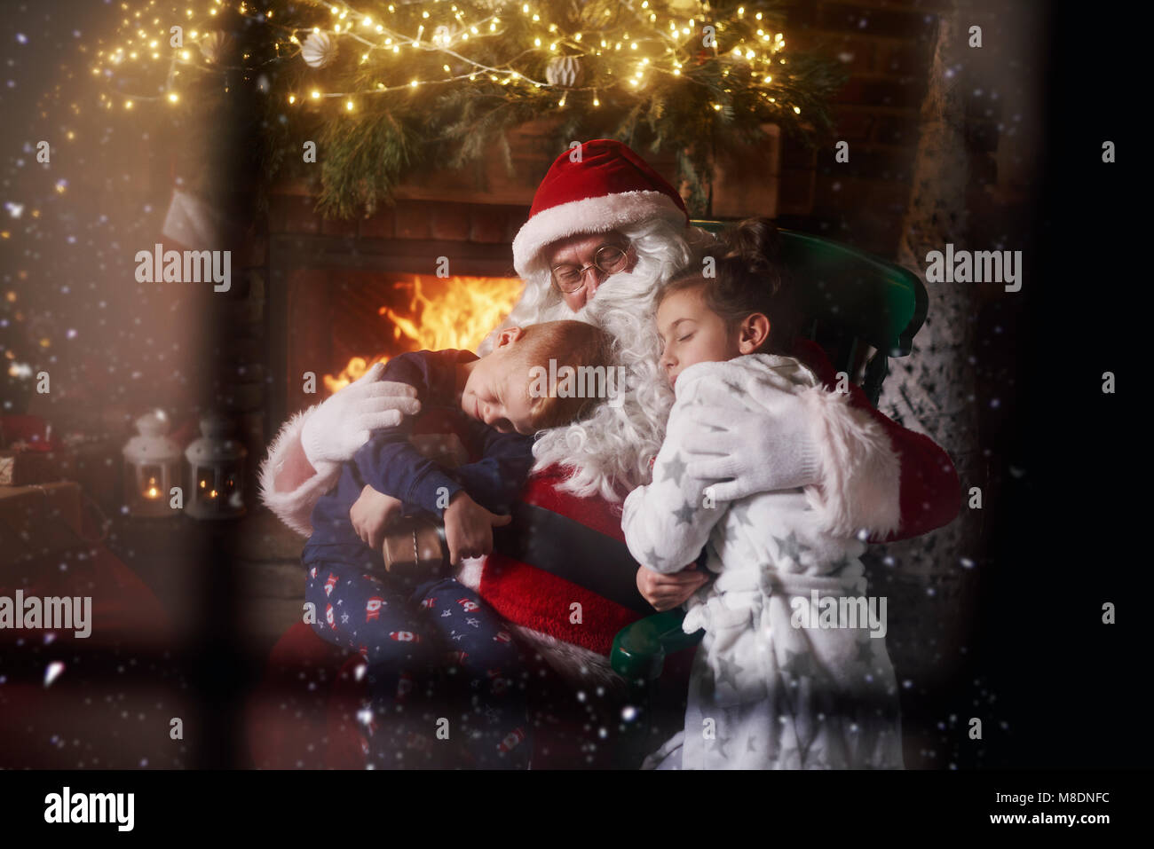 Santa Claus hugging young boy and girl, beside fireplace Stock Photo ...