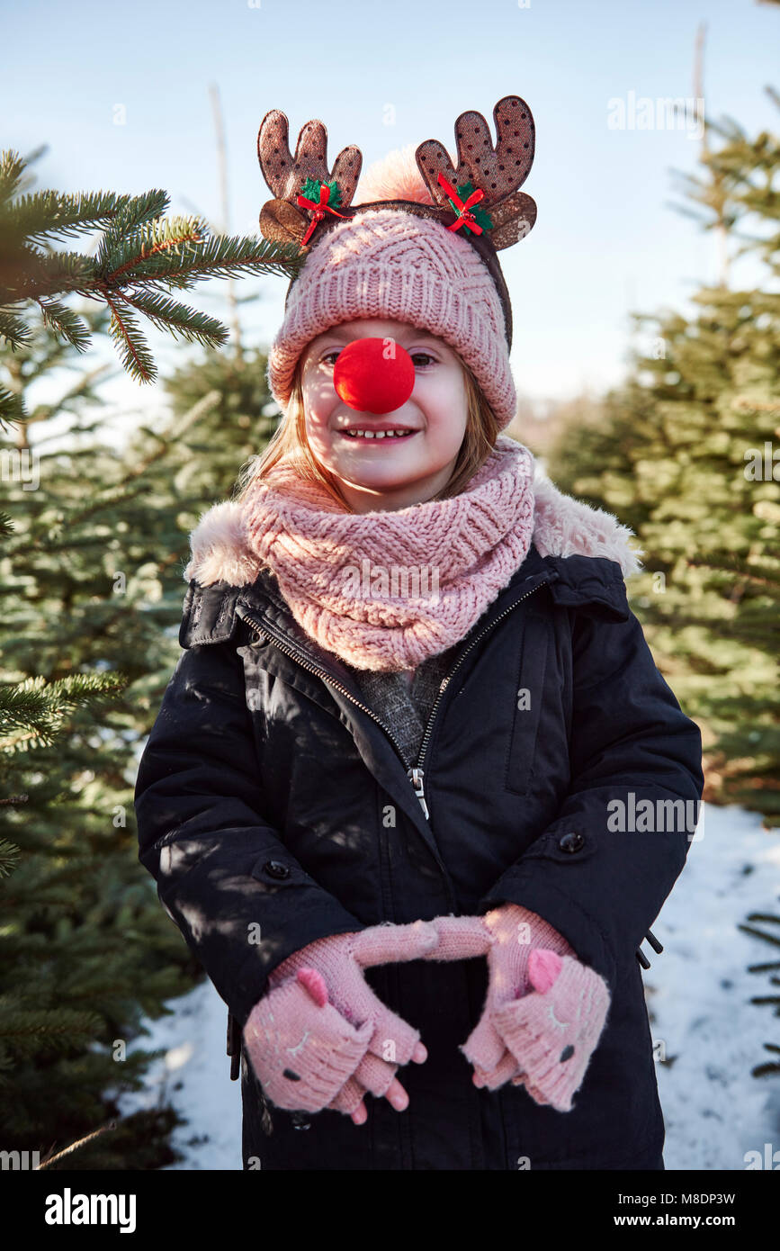 Girl in christmas tree forest with red nose, portrait Stock Photo - Alamy