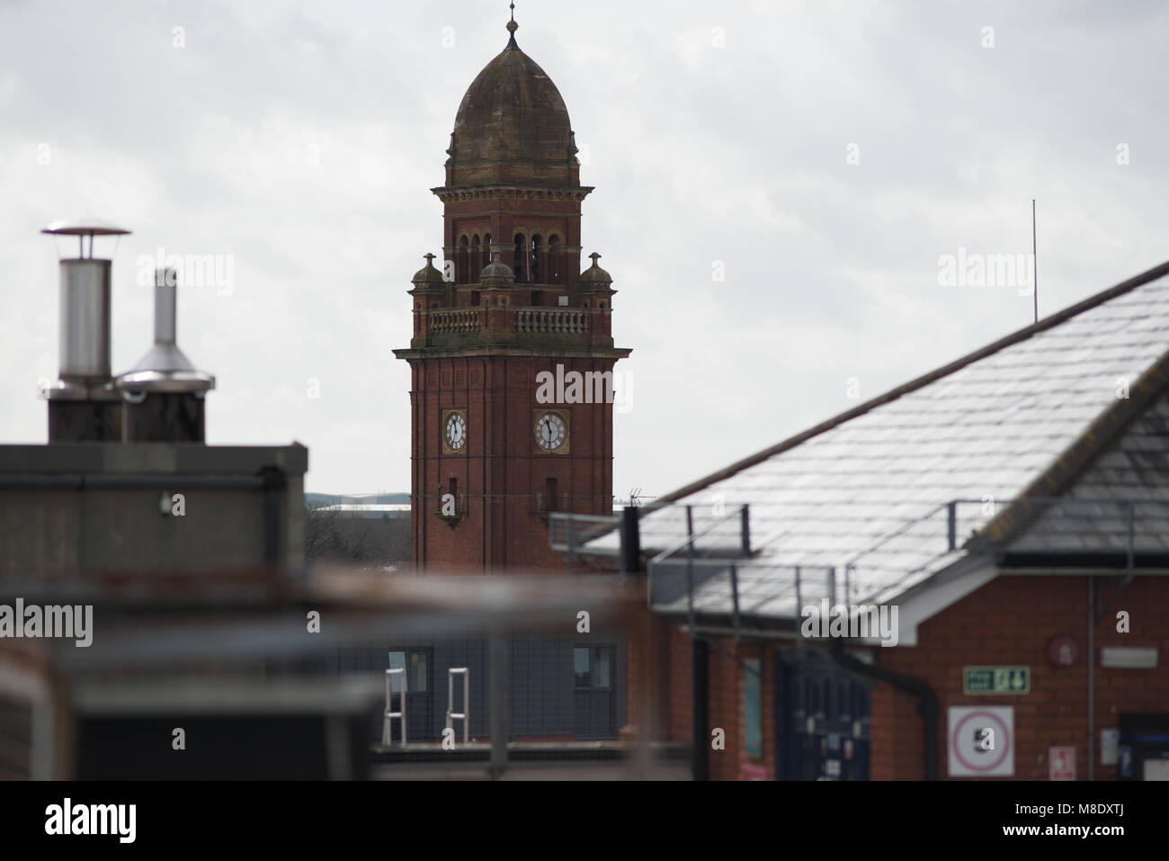 rooftop view of clock tower and metal chimney stacks in typical English ...