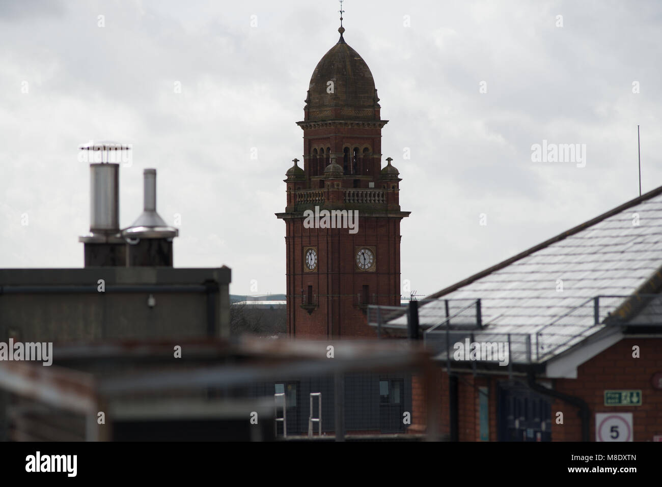 rooftop view of clock tower and metal chimney stacks in typical English ...
