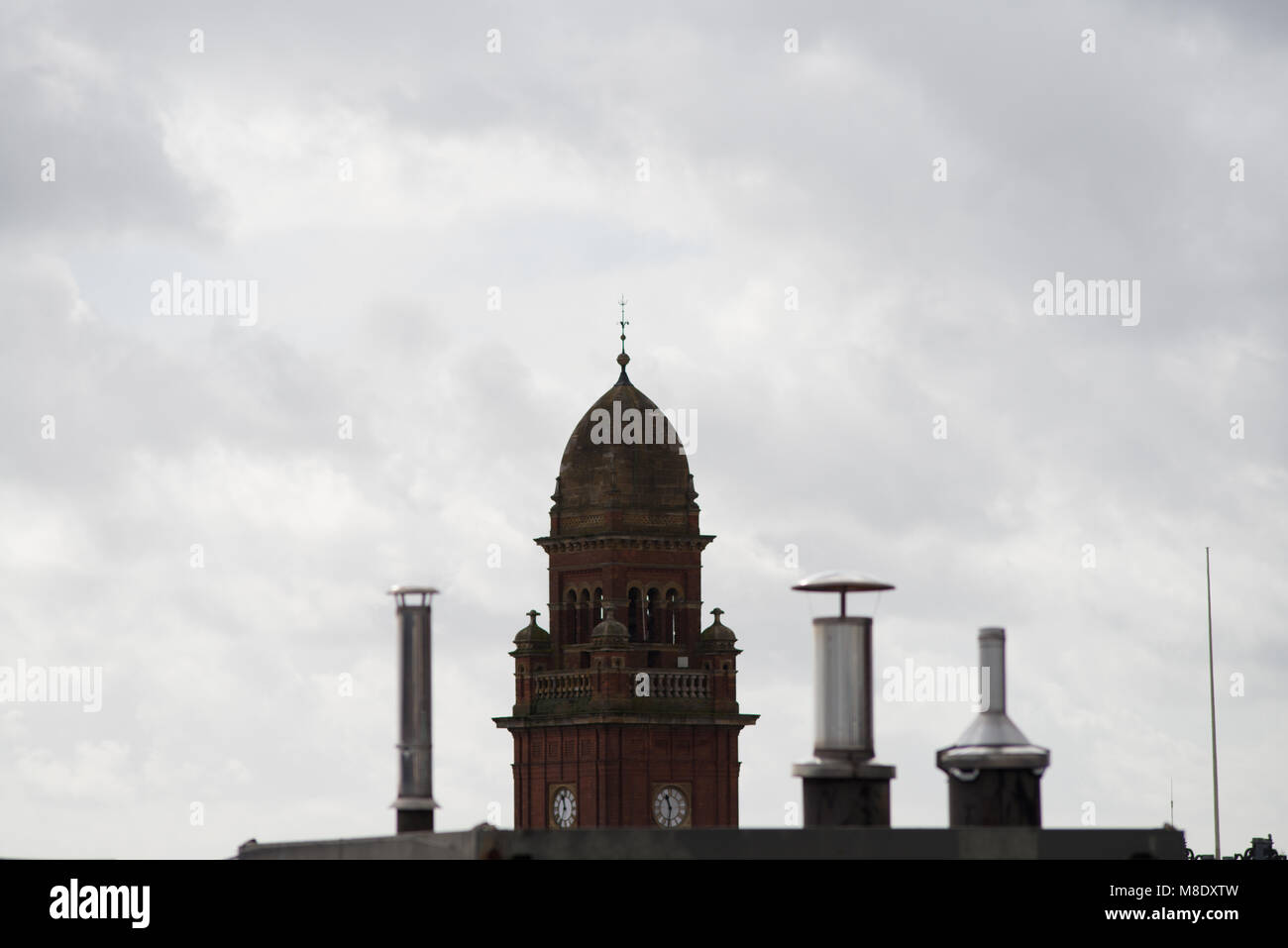 rooftop view of clock tower and metal chimney stacks in typical English ...