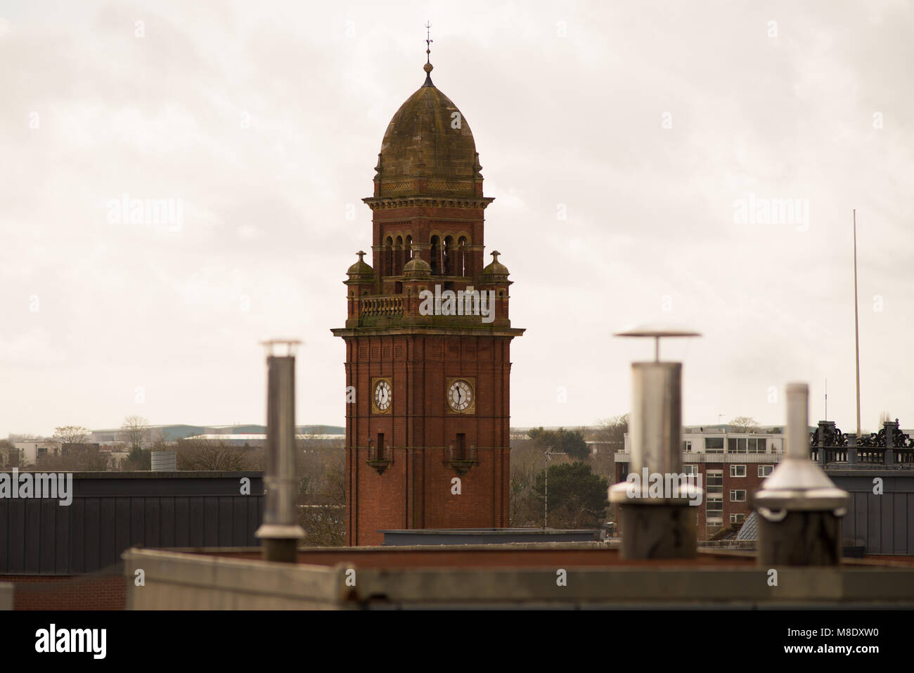 rooftop view of clock tower and metal chimney stacks in typical English ...
