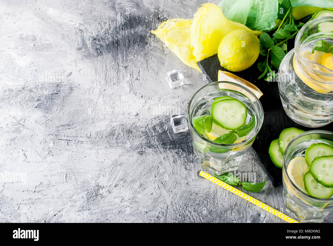 Refreshing cucumber cocktail, lemonade, detox water in a two glasses on a grey background ...
