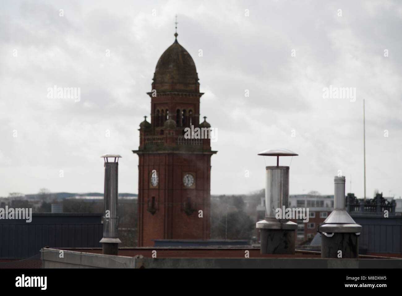 rooftop view of clock tower and metal chimney stacks in typical English ...
