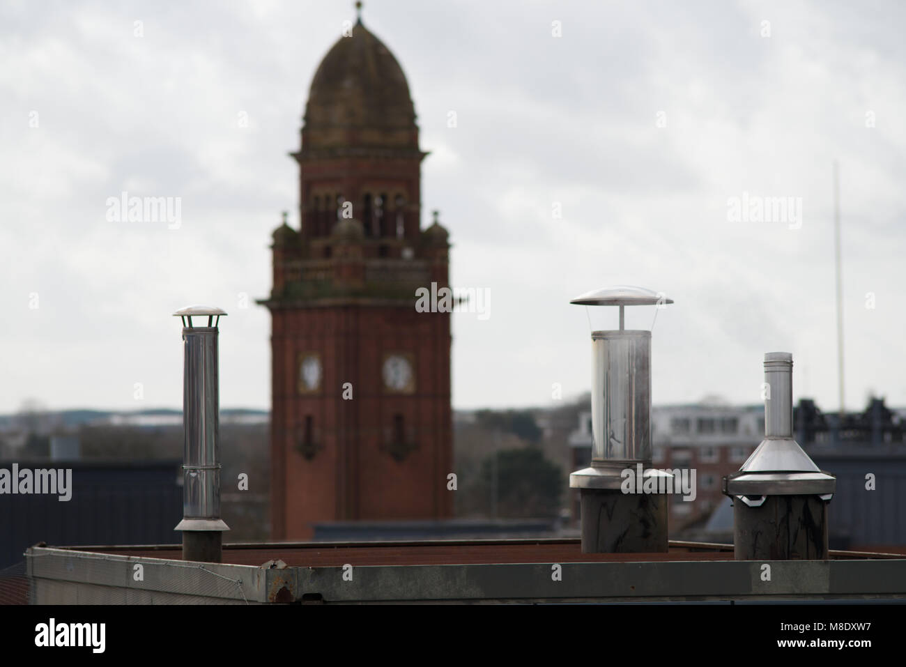 rooftop view of clock tower and metal chimney stacks in typical English ...