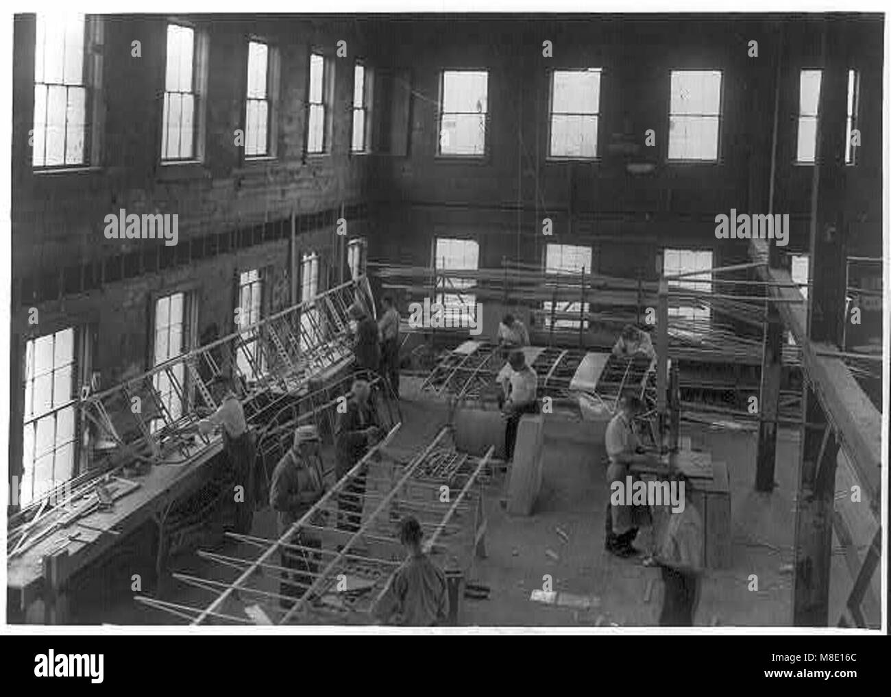 Workers assembling wings for airplanes, reflecting the manufacturing ...