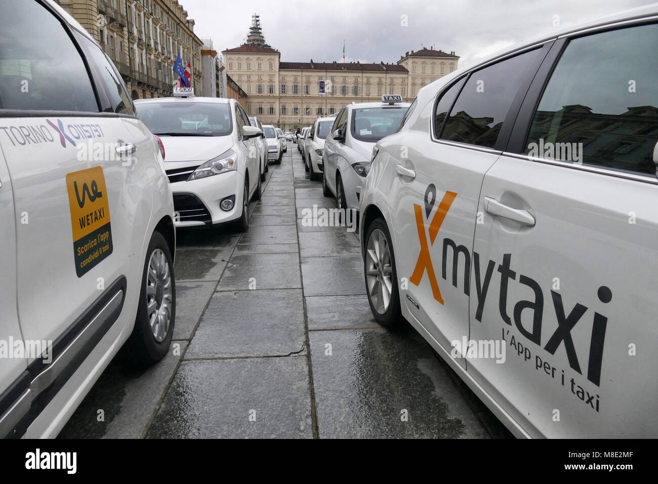 Taxi cab parked in rows waiting customers with mobile app logo showed ...