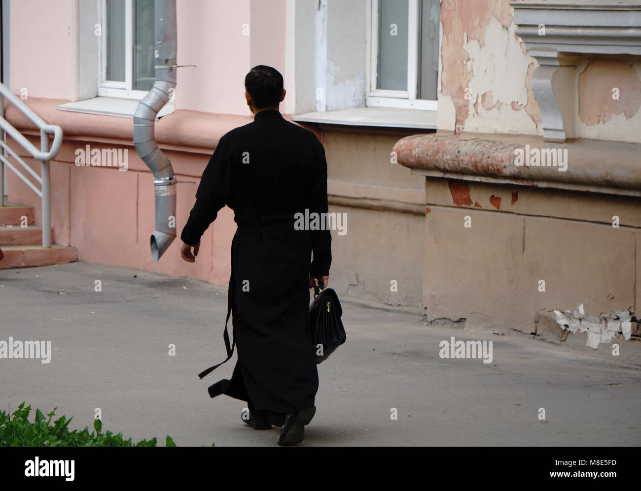Priest praying to God. Handsome young catholic priest read the Bible ...