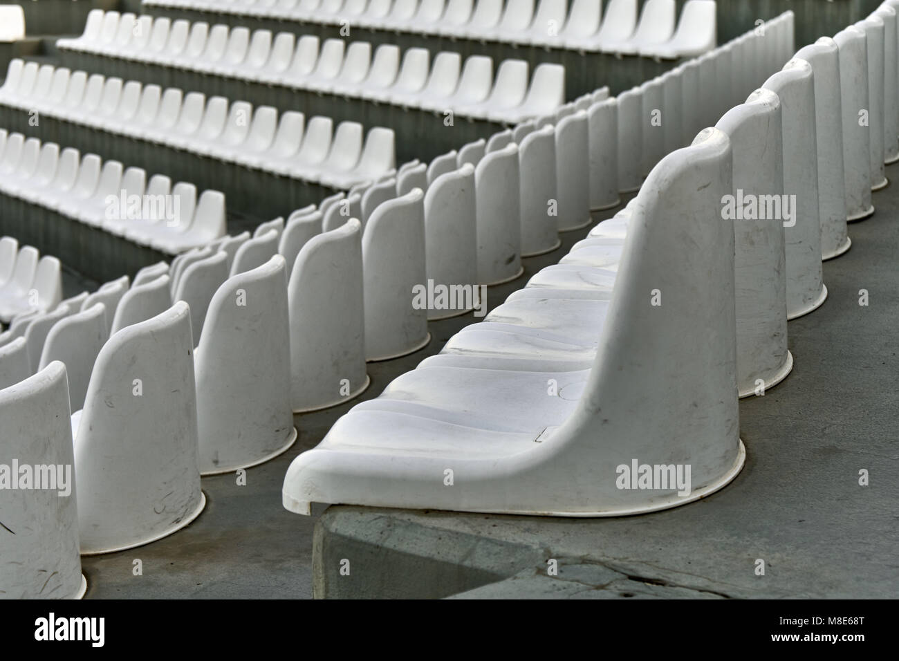 Straight rows of contemporary chairs made of white plastic on ...