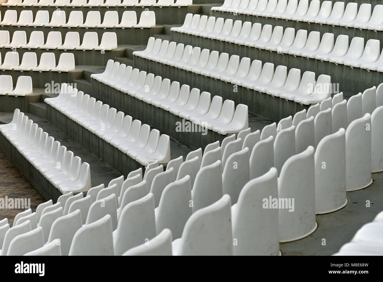 Straight rows of contemporary chairs made of white plastic on ...
