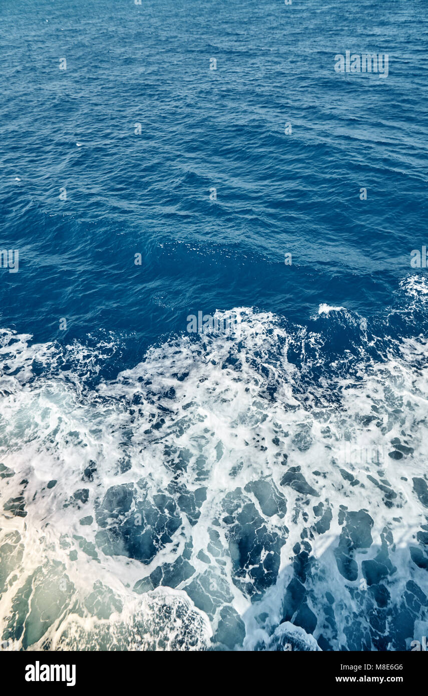 White foam trail on sea surface behind a moving ship view from above ...