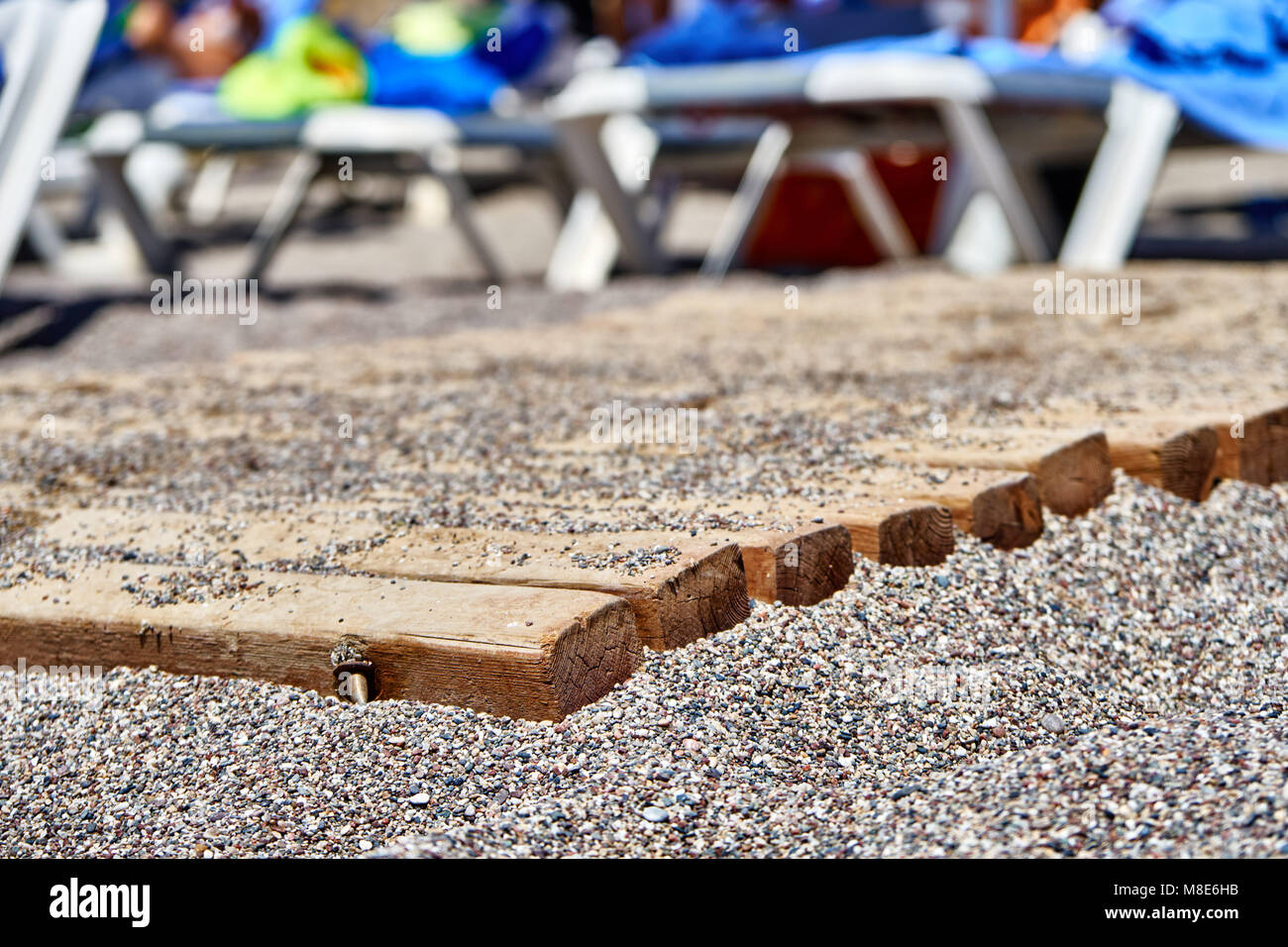 Wooden pathway on pebble beach for comfortable walking to water extreme ...