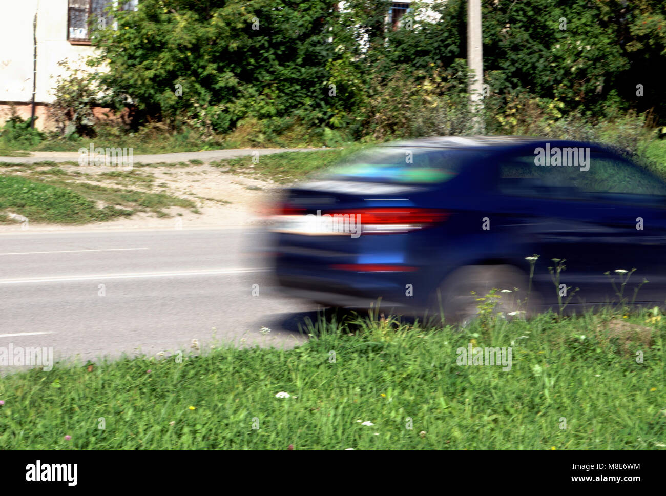 Speeding concept - motion blurred car going fast on a small road up the ...