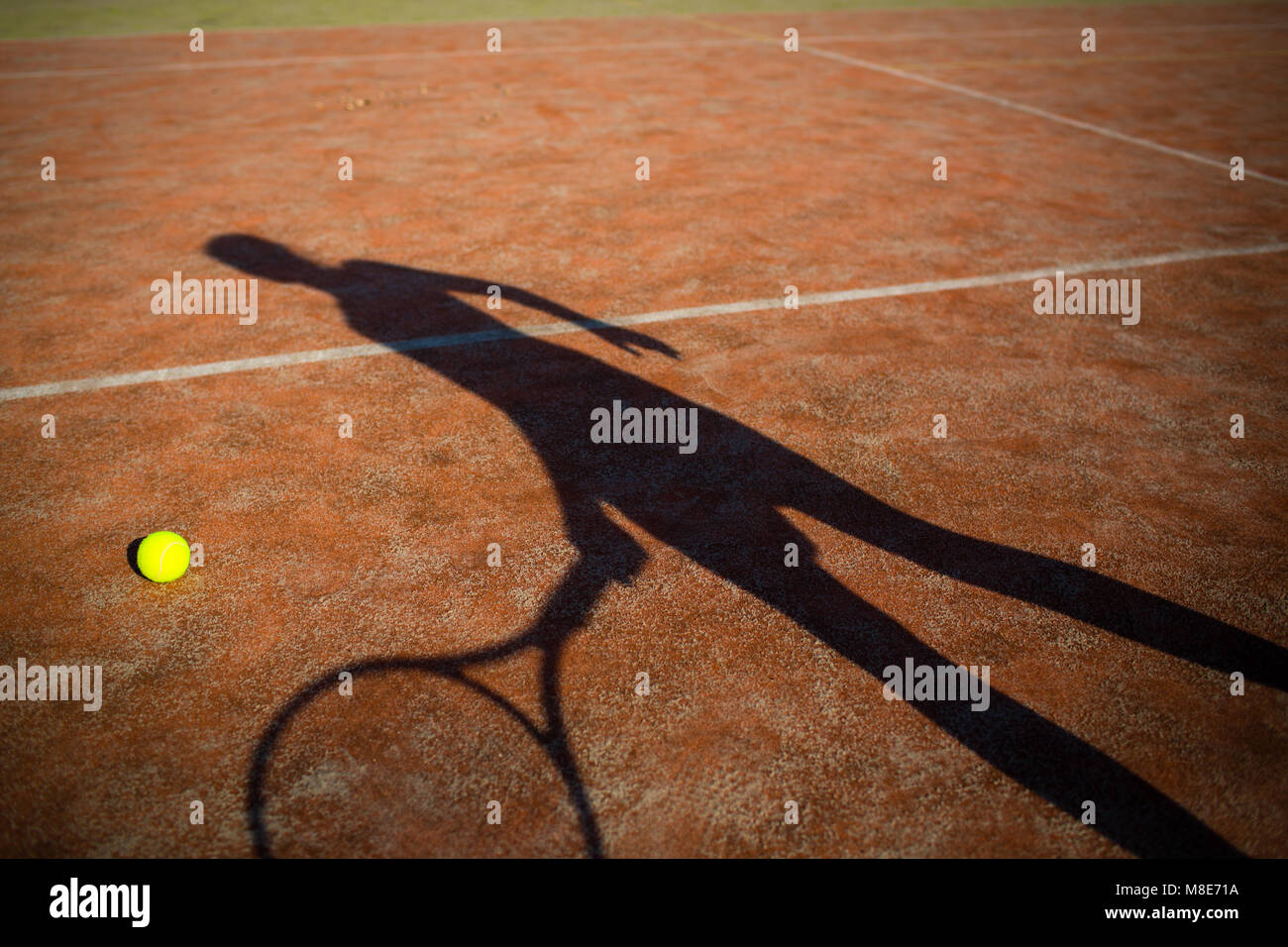 shadow of a tennis player in action on a tennis court (conceptual image ...