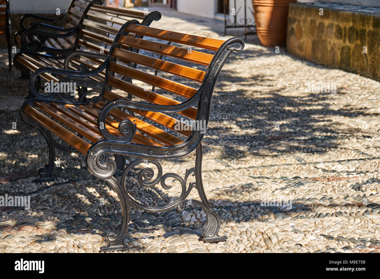 Benches standing on a pebble in a shady place Stock Photo - Alamy
