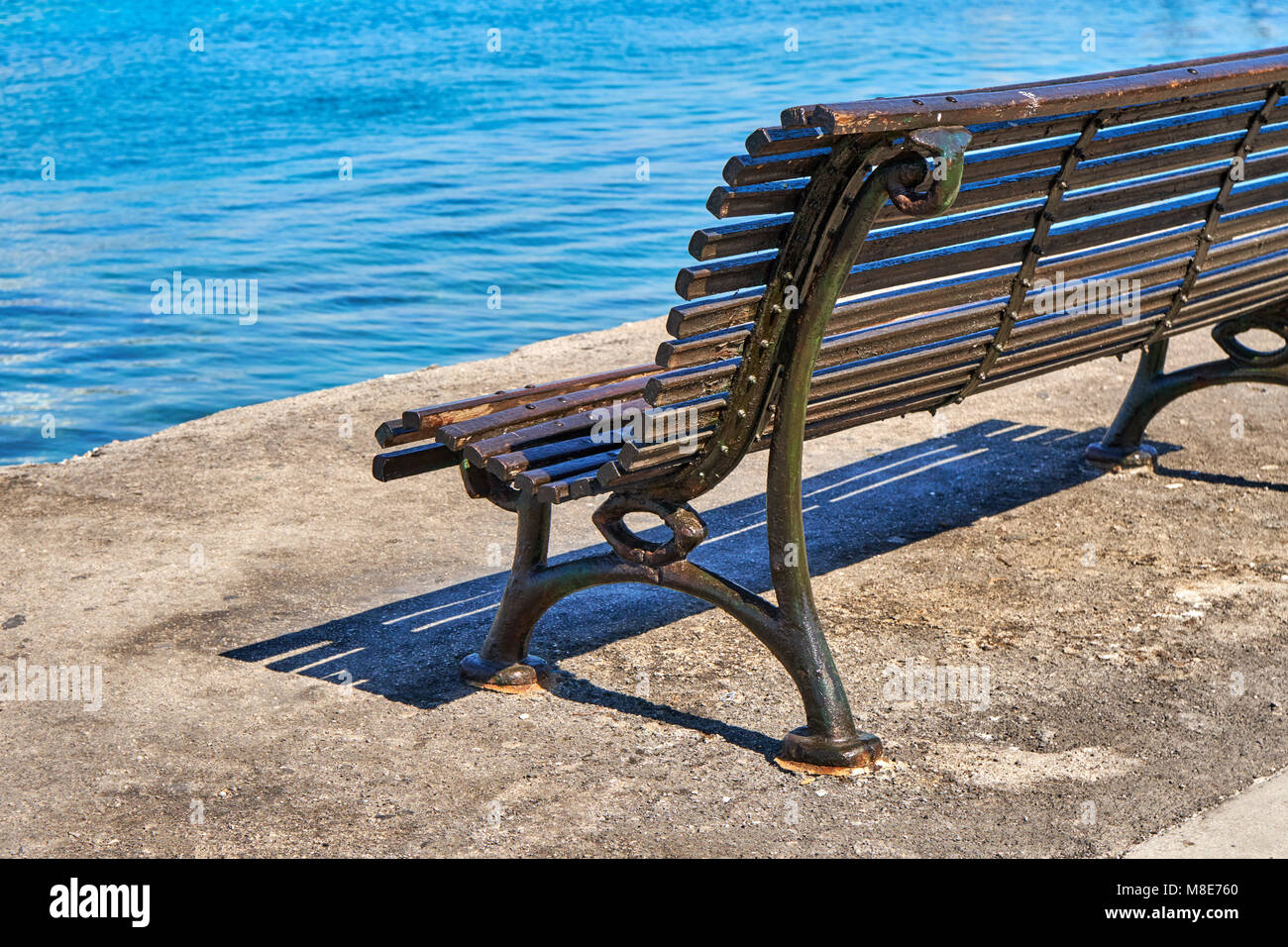 Lonely bench standing on a promenade by the sea Stock Photo - Alamy