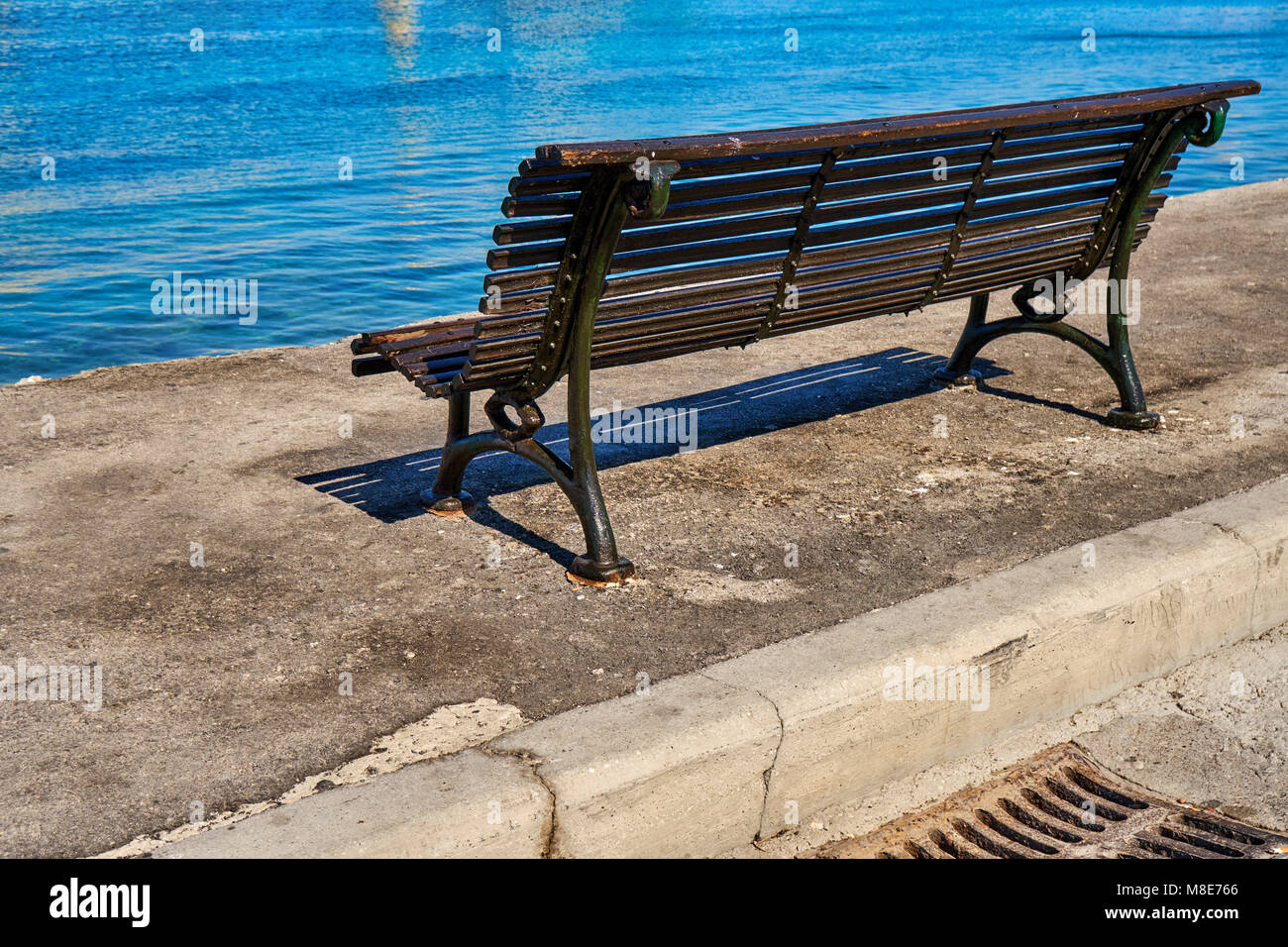 Lonely bench standing on a promenade by the sea Stock Photo - Alamy
