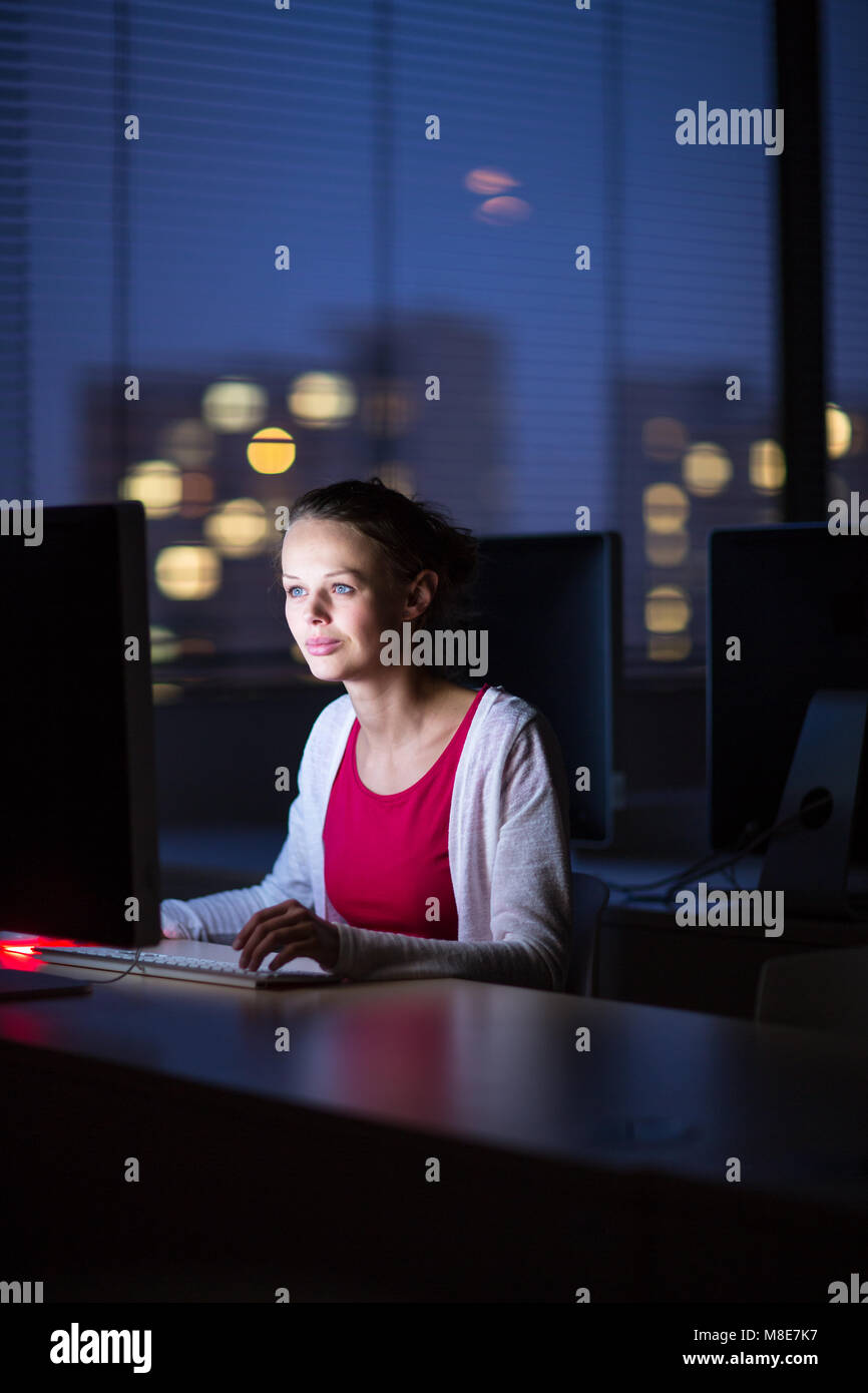 Pretty, young female college student using a desktop computer/pc in a ...