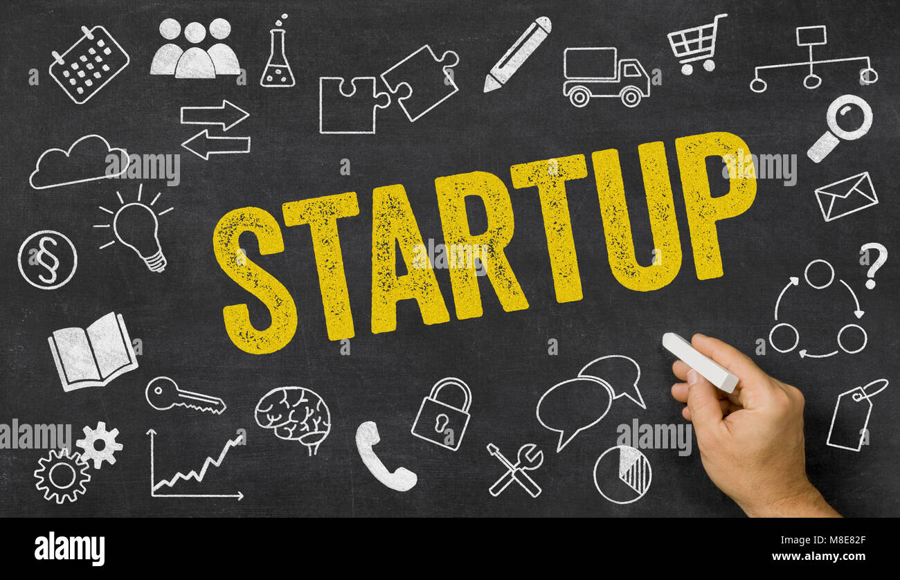 Startup written on a blackboard with icons Stock Photo - Alamy