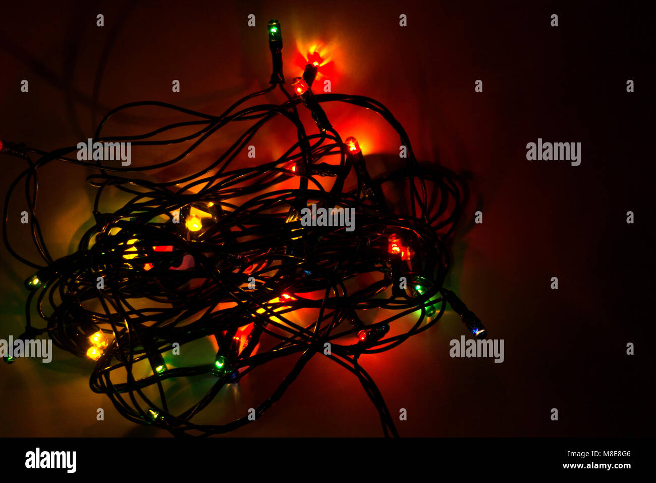 Dark Colorful Christmas background, garland lights on wooden floor with ...