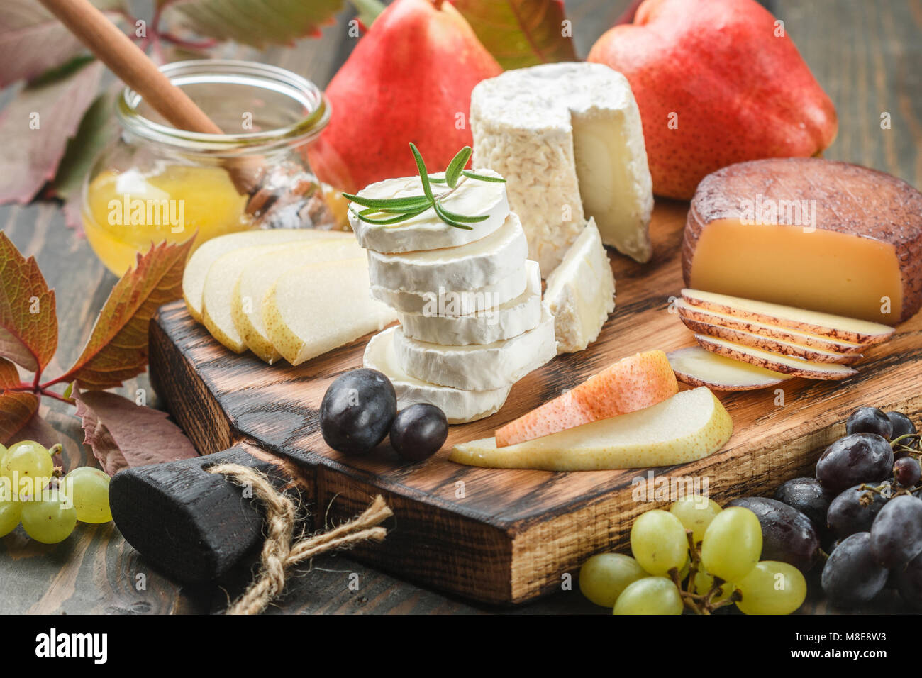 Set of fine cheeses with fruit and honey. Camembert. Bree. Grapes ...