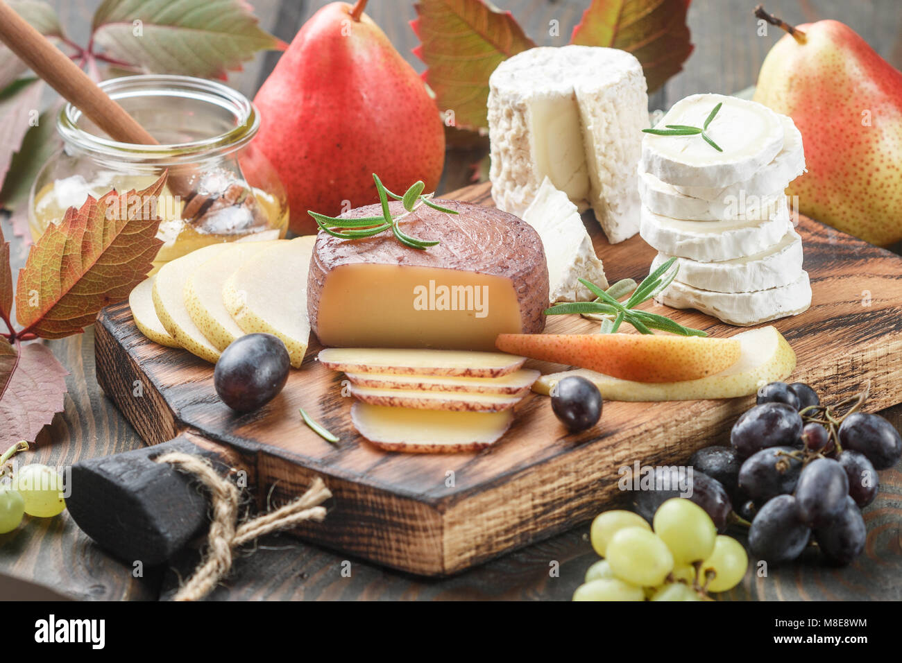 Set of fine cheeses with fruit and honey. Camembert. Bree. Grapes ...