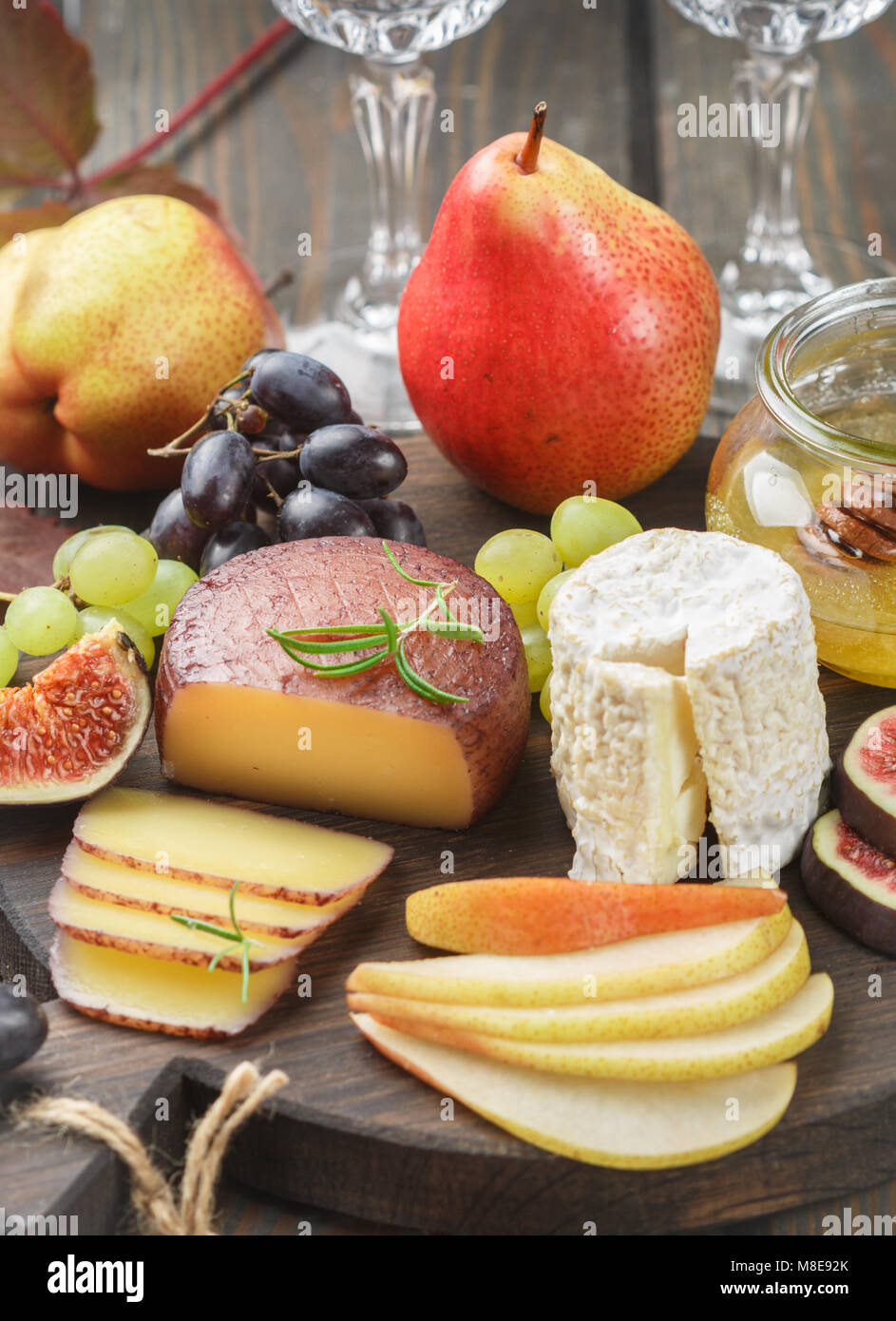 Set of fine cheeses with fruit and honey. Camembert. Bree. Grapes, figs ...