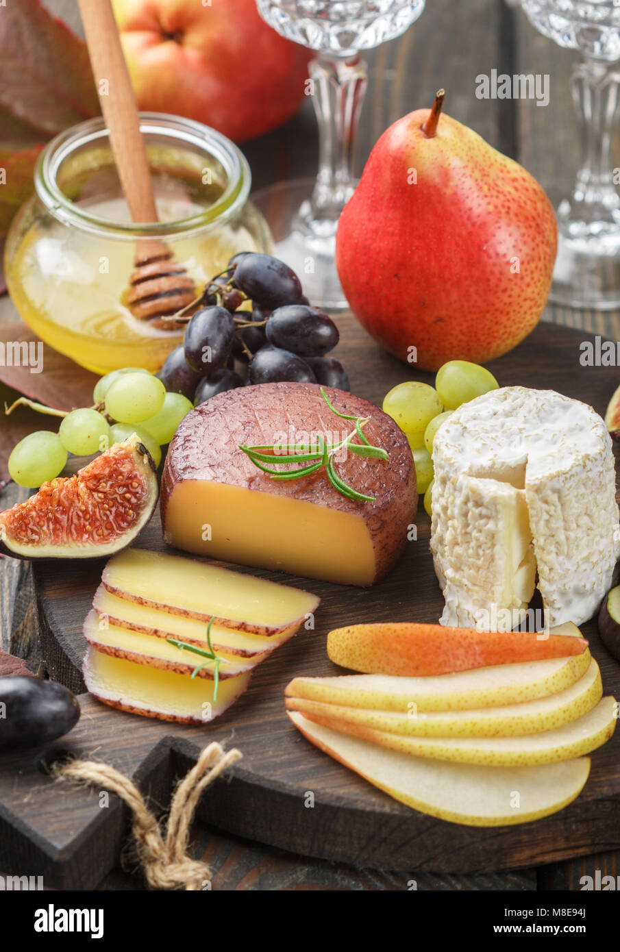 Set of fine cheeses with fruit and honey. Camembert. Bree. Grapes, figs ...