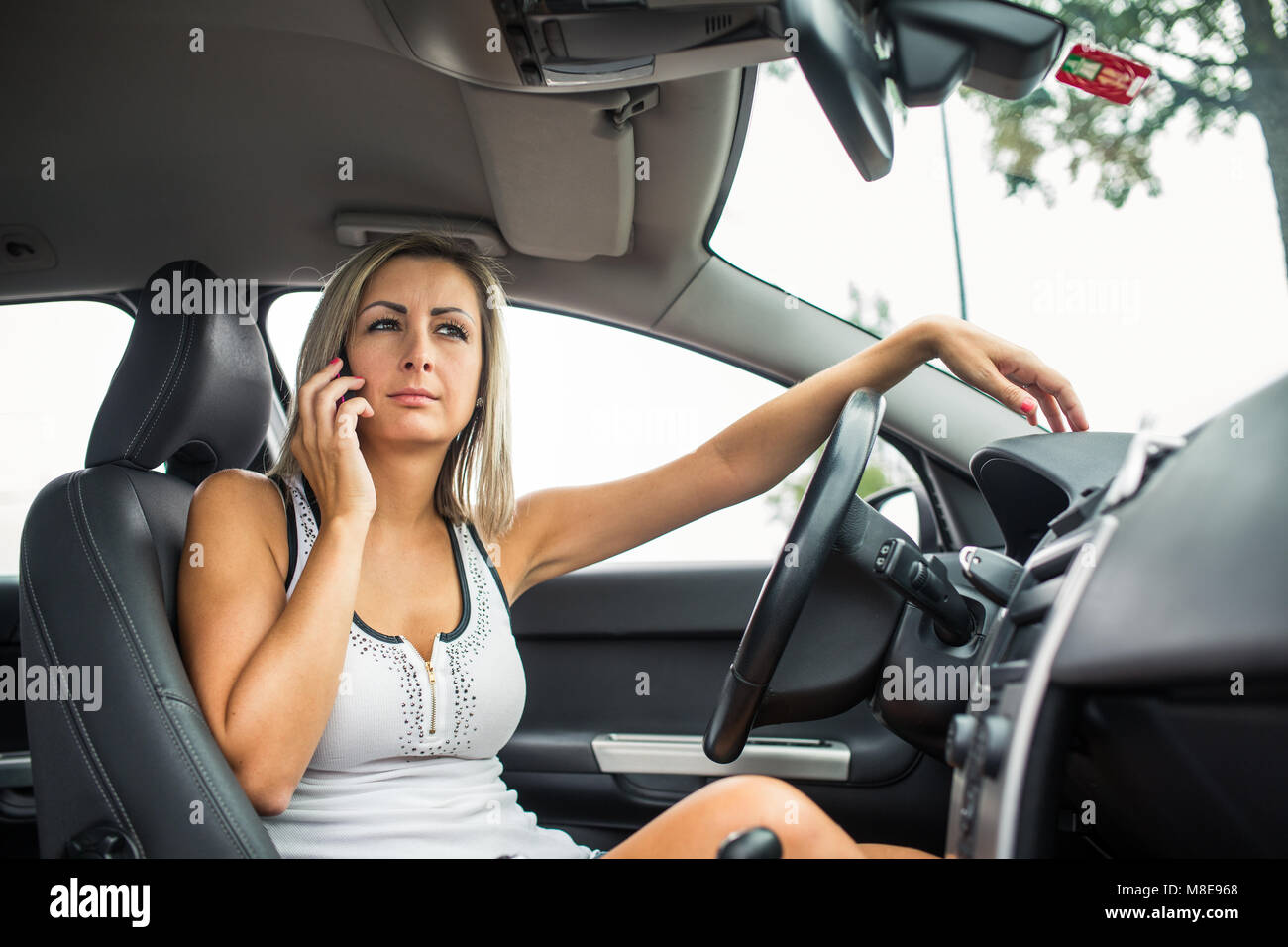 Woman driving a car - female driver at a wheel of a modern car, looking ...