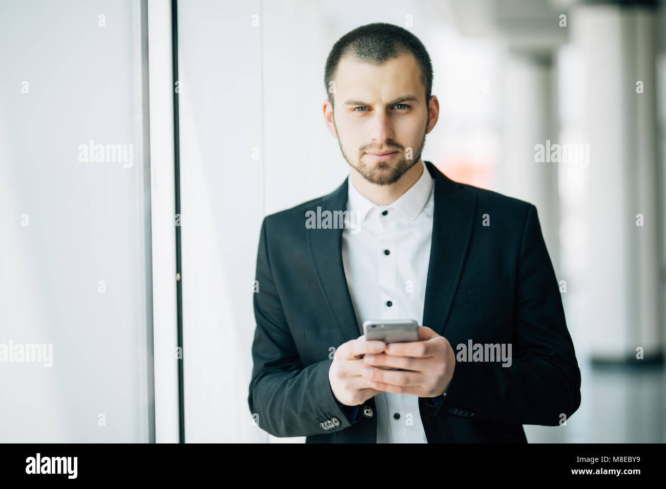 Handsome caucasian businessman dressed in the suit reading with his ...