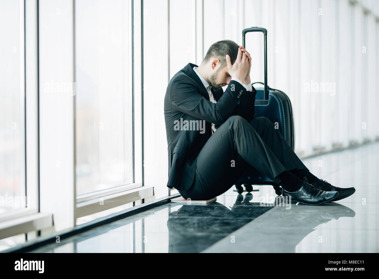 Serious businessman worrying something, sitting and touch his head at ...