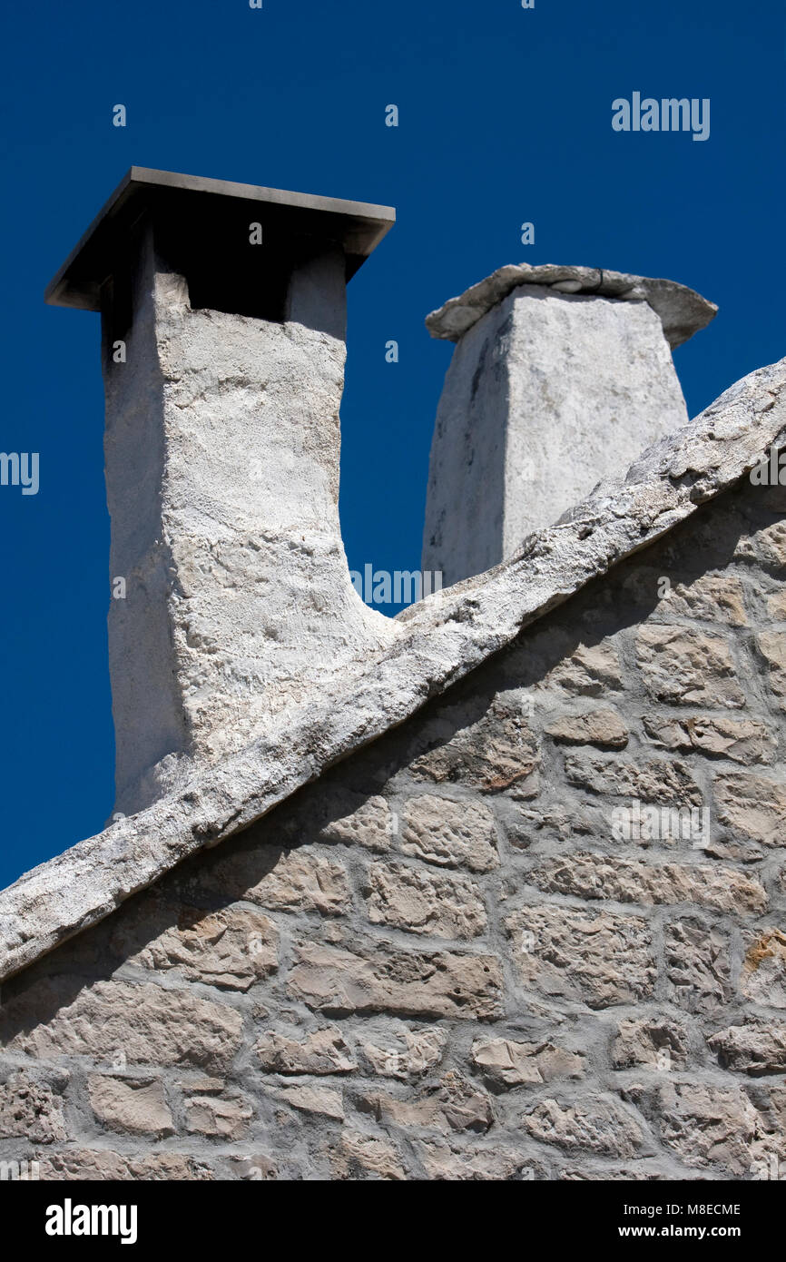 White painted chimneys on old mediterranean stone house in Croatia on ...