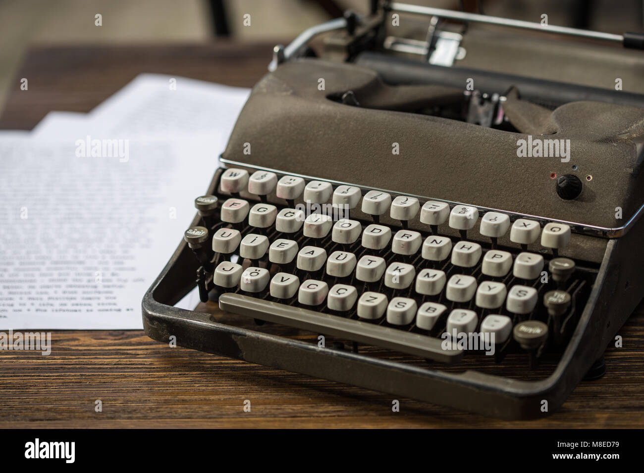 Gray retro typewriter with white keys on wooden tabletop Stock Photo ...