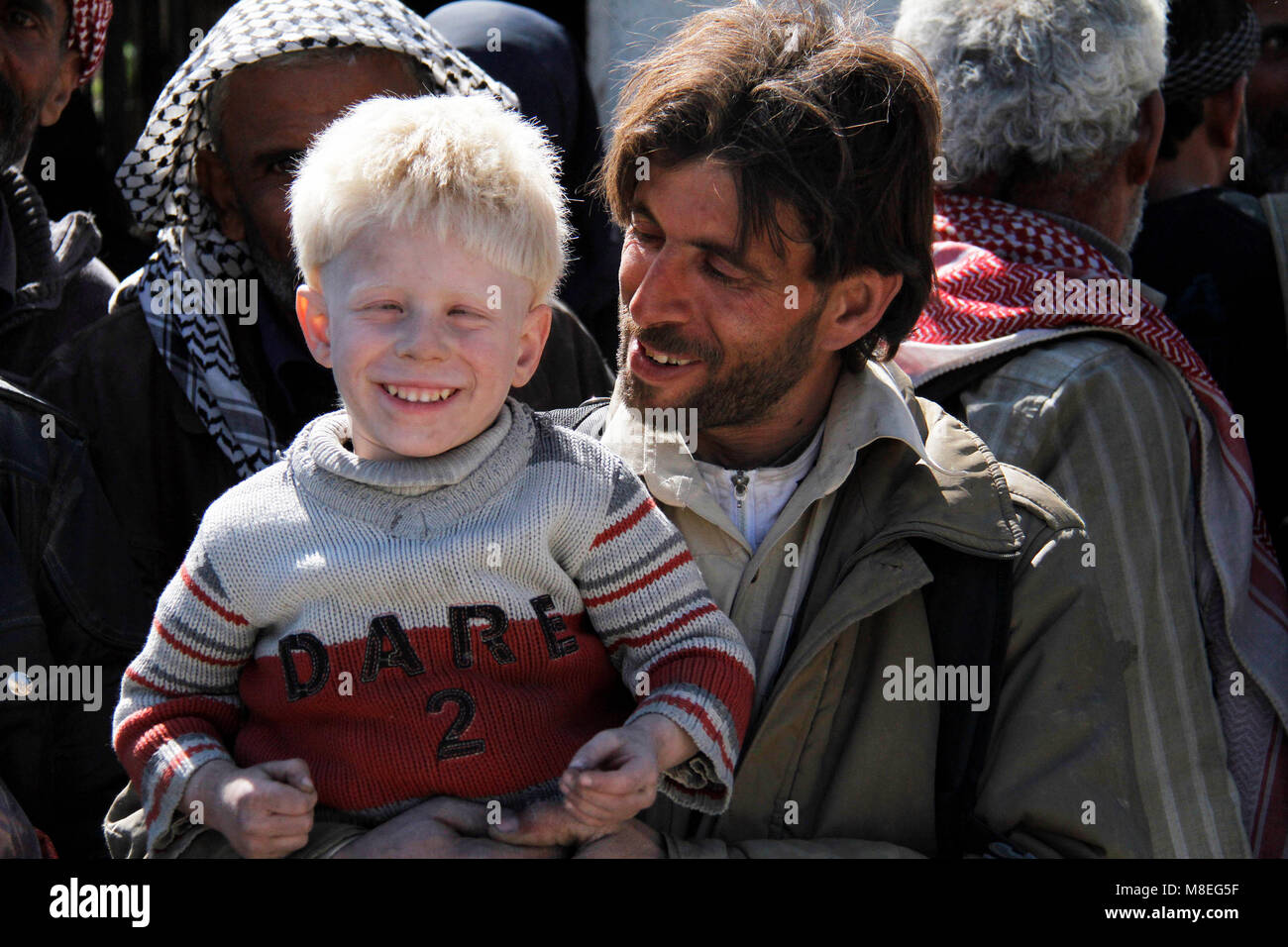 Damascus, Syria. 16th Mar, 2018. A Syrian boy smiles as his father ...
