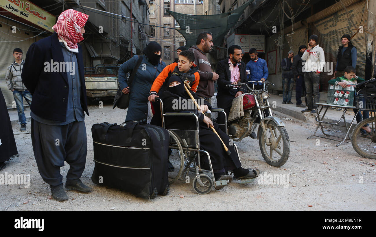 Syrians prepare to ride on a Syrian Arab Red Crescent bus before being ...