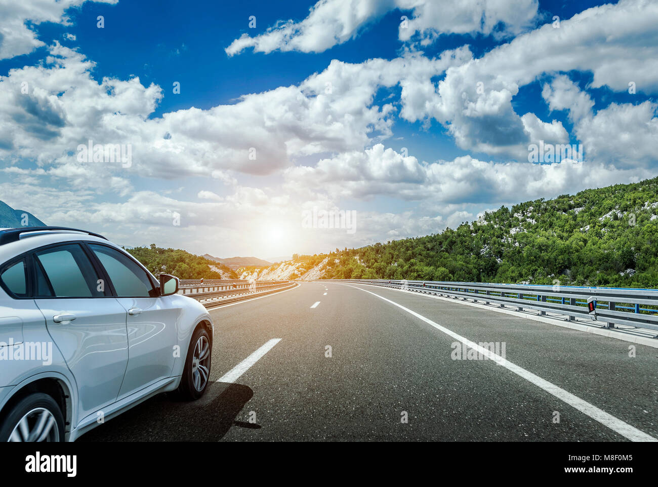 A white car rushing along a high-speed highway in the sun Stock Photo ...