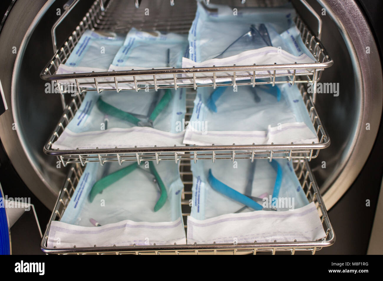 Sterilizing medical instruments in autoclave, Tongs for manicure on the ...