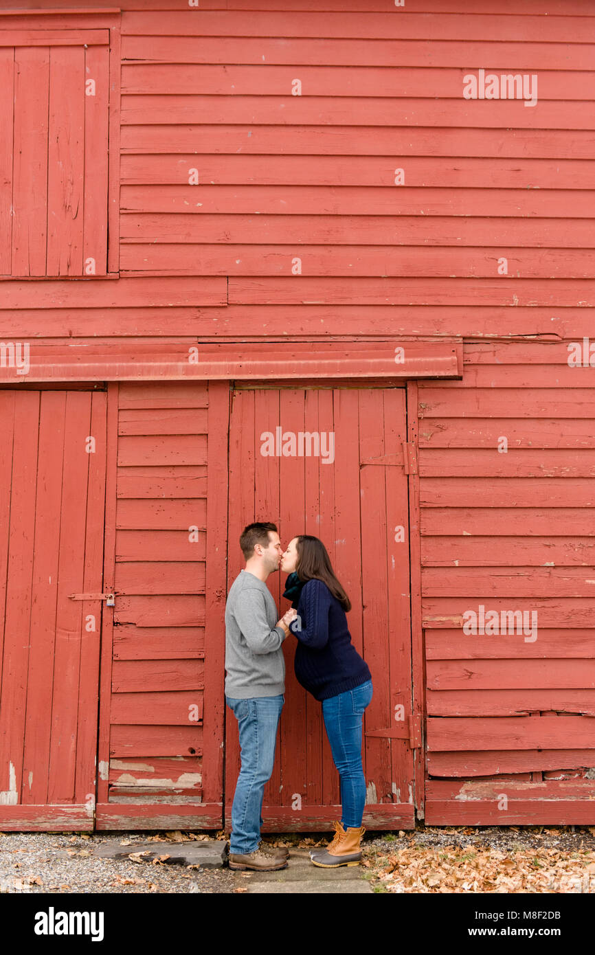 Couple kissing in front of red barn Stock Photo - Alamy