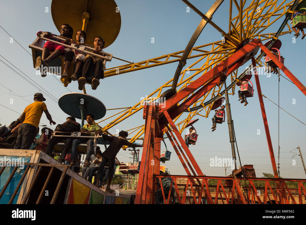 People riding on a Ferris wheel in the late afternoon at the Sonepur ...