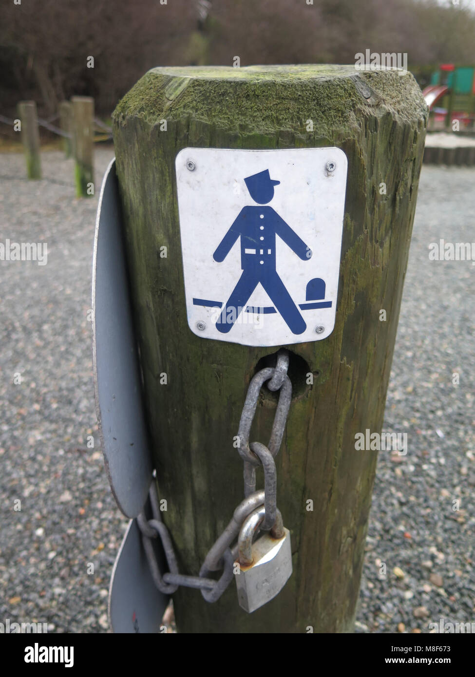 Notice on post depicting a blue Gendarm policeman guarding coastal path ...