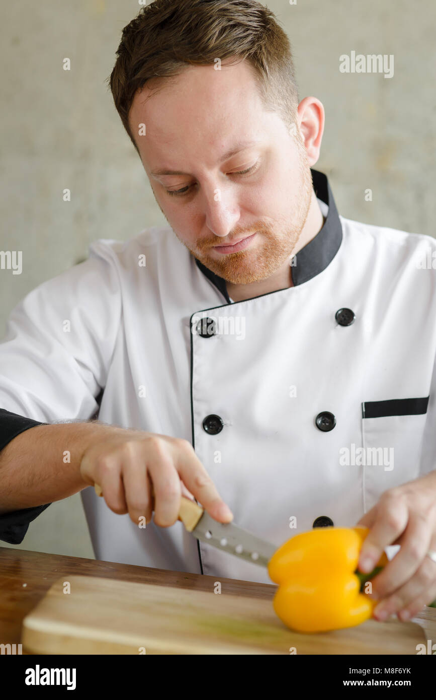 Professional chef chopping chili peppers for preparing food Stock Photo ...