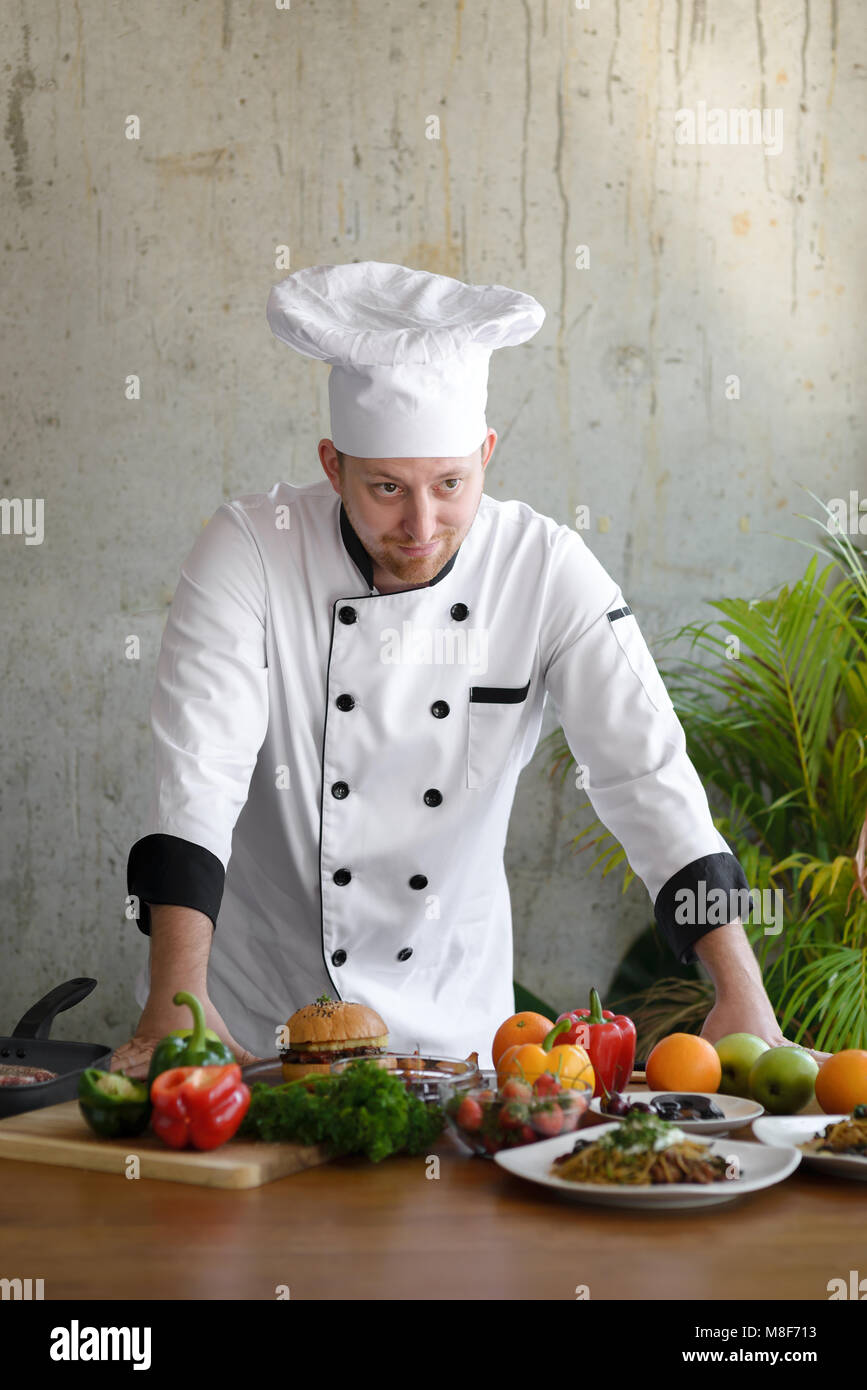 Professional chef looking at food and vegetable on table Stock Photo ...