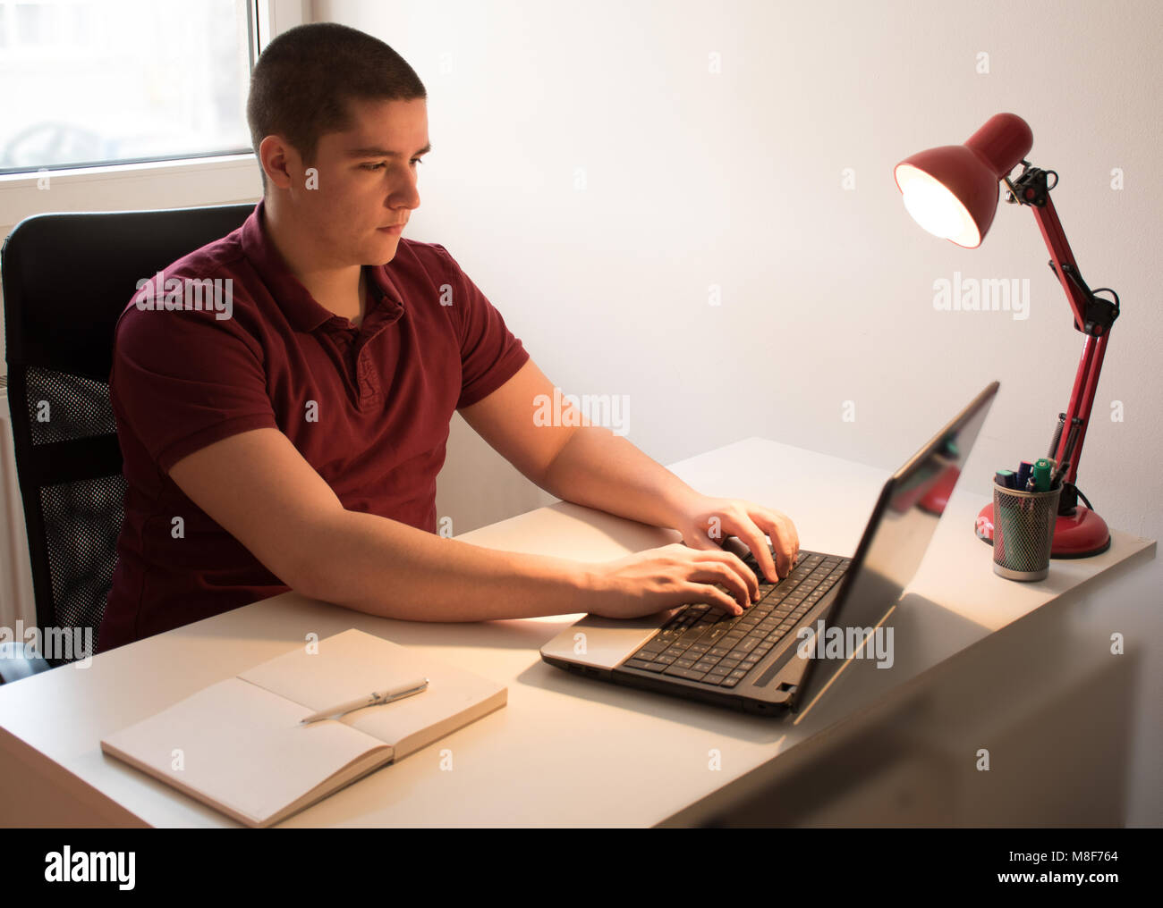 Teenager working on laptop in his room Stock Photo - Alamy