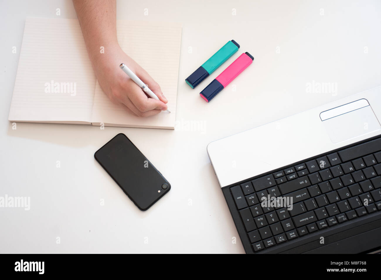 writing homework on the desk next to laptop and phone Stock Photo - Alamy